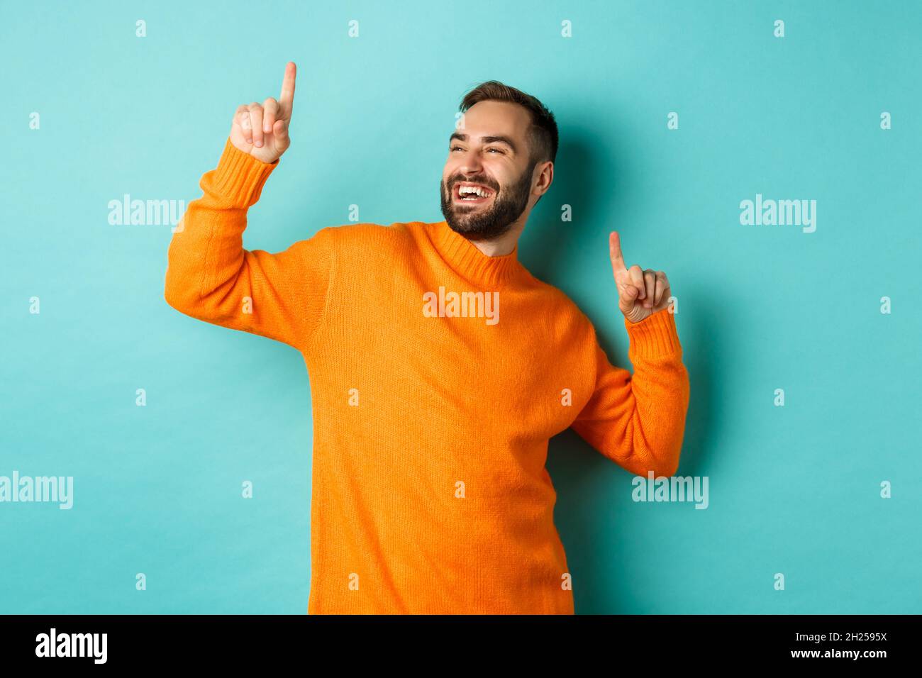 Handsome man celebrating, feeling winner, pointing fingers up and do ...
