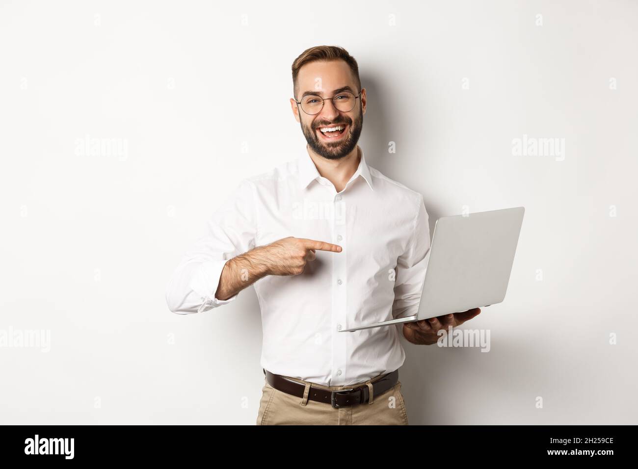 Business. Handsome manager in glasses working on laptop, pointing at ...