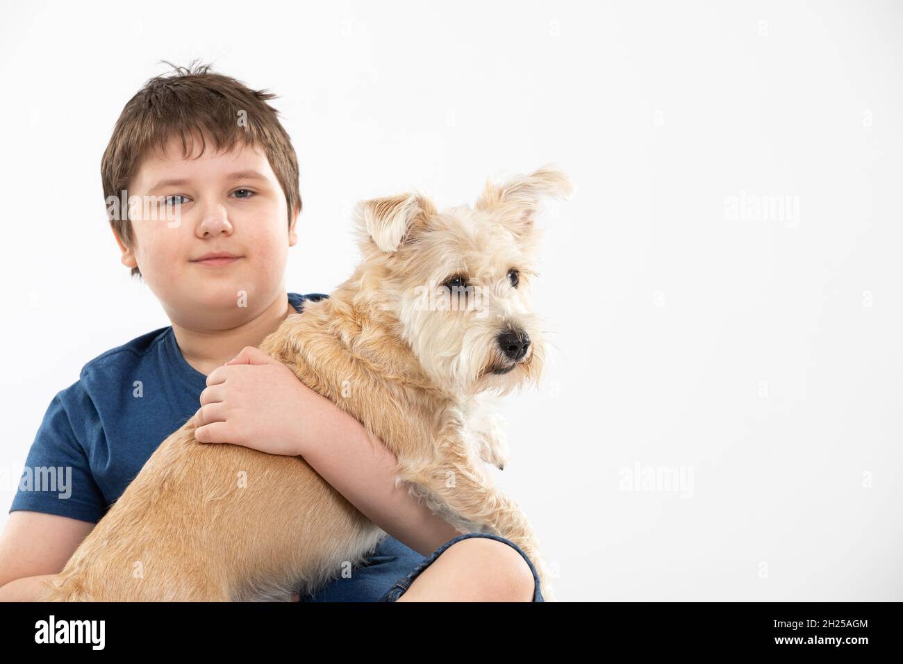 Young boy holds his dog in his arms. Subject isolated from the ...