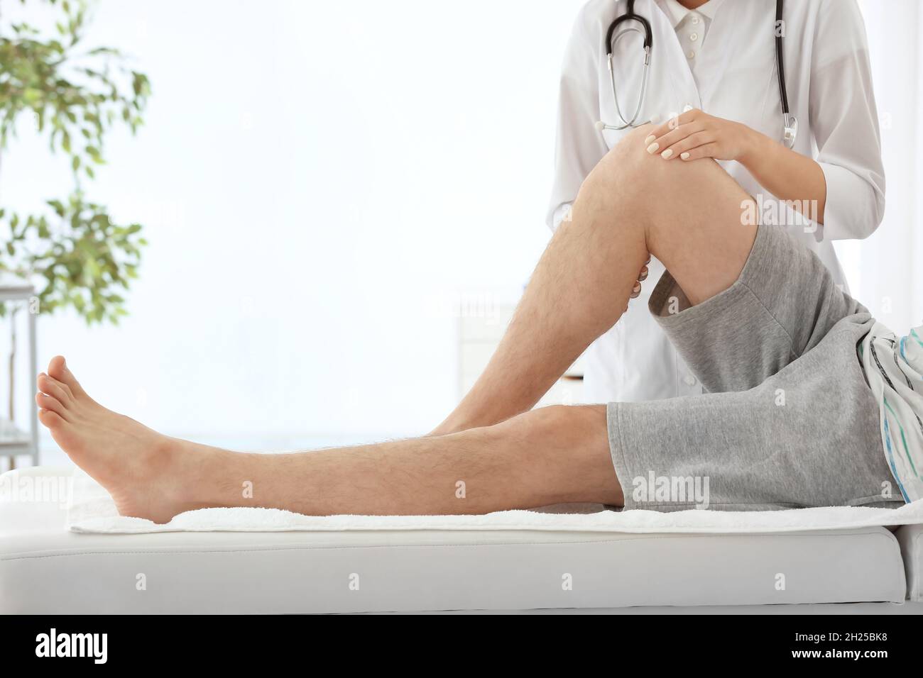 Doctor examining male patient with injured leg, closeup Stock Photo - Alamy