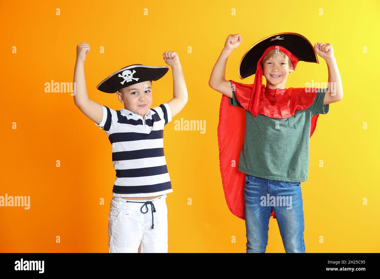 Adorable little children playing pirates on color background. Indoor ...