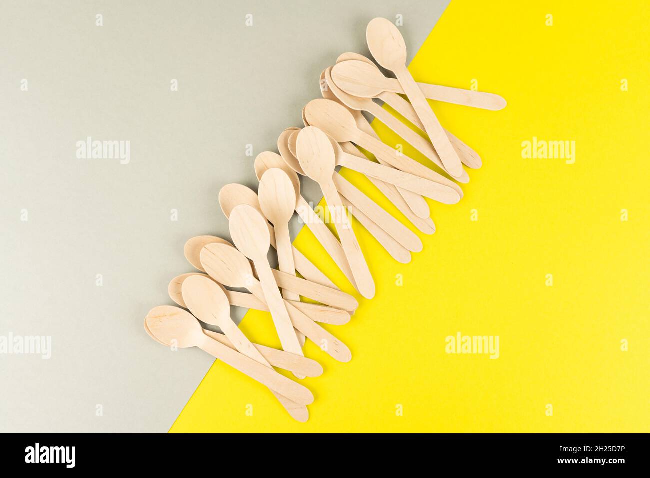 Wooden spoons for fast food lie at the intersection of gray and yellow ...
