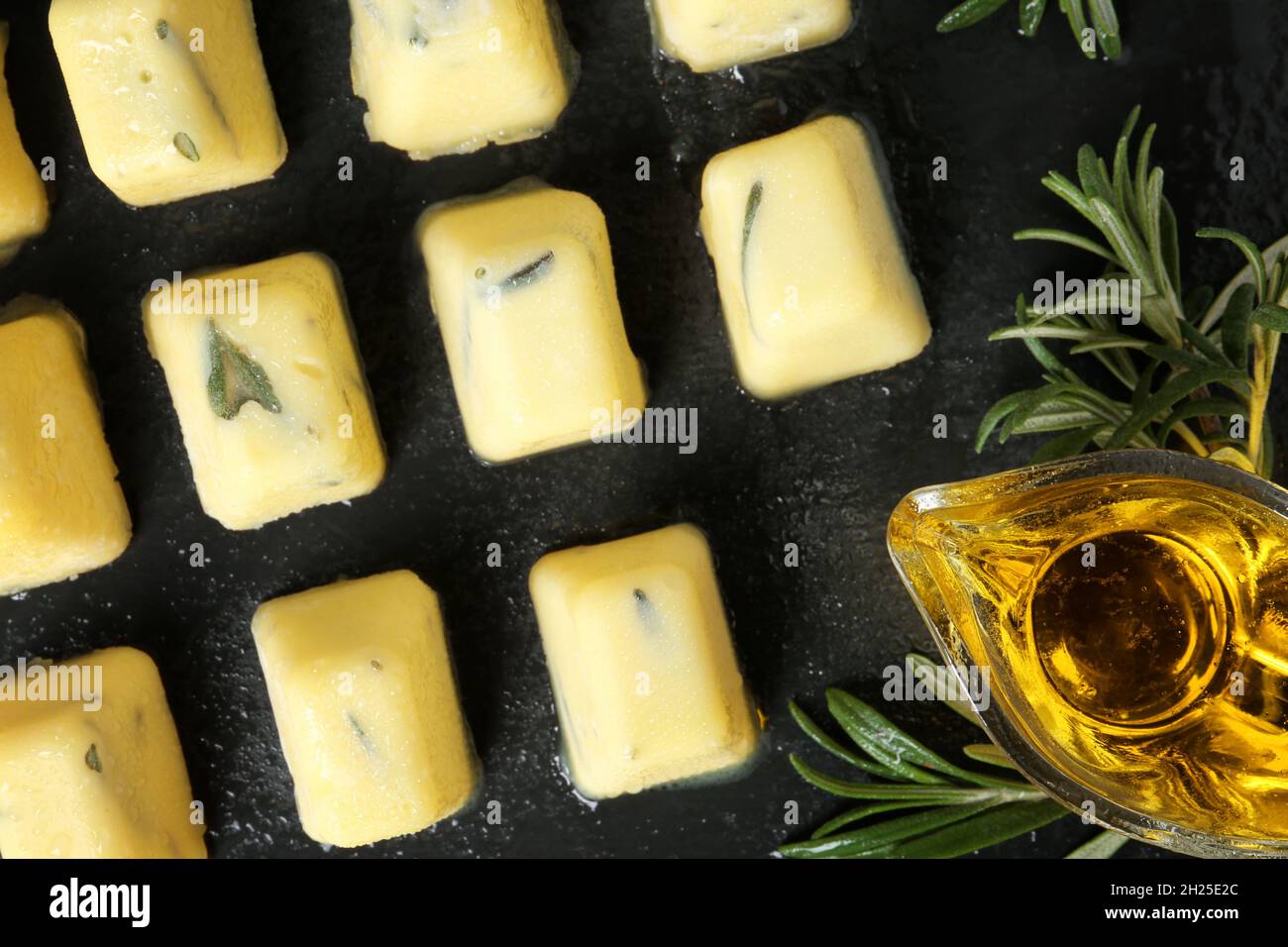 Flat lay composition with rosemary and olive oil ice cubes on dark ...
