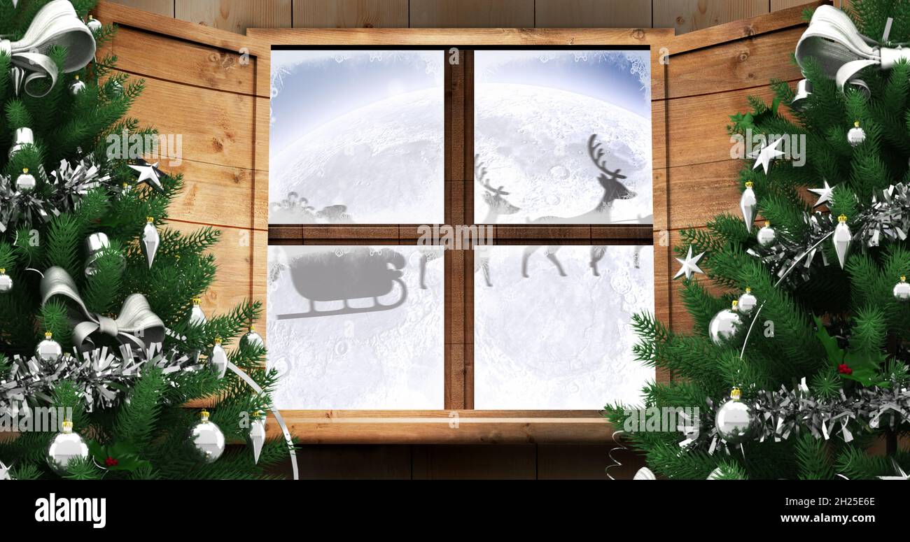 Image of santa claus in sleigh with reindeer seen seen through window ...