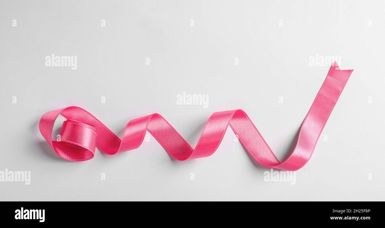 Simple pink ribbon on white background, top view Stock Photo - Alamy