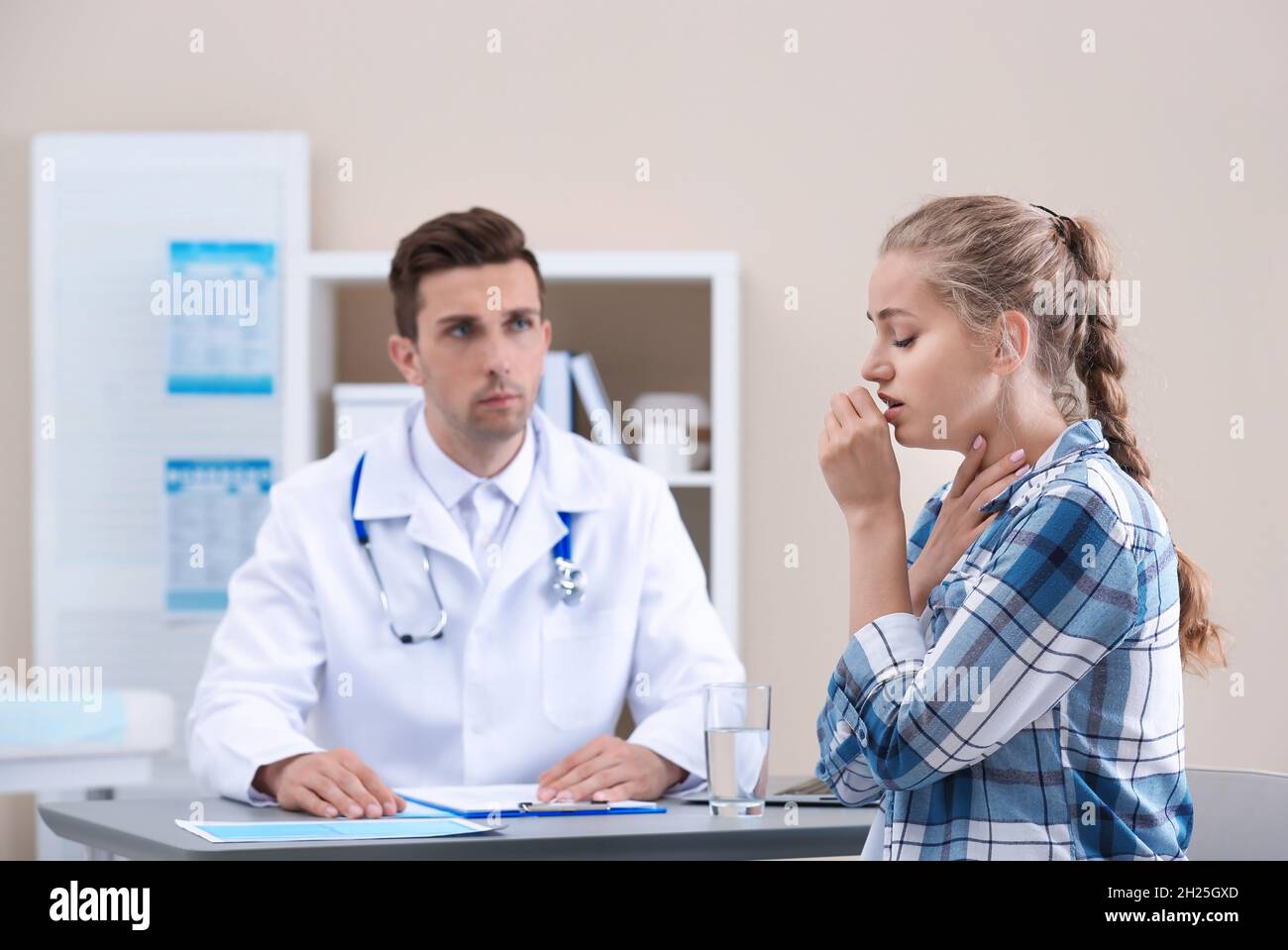 Coughing young woman visiting doctor at clinic Stock Photo - Alamy