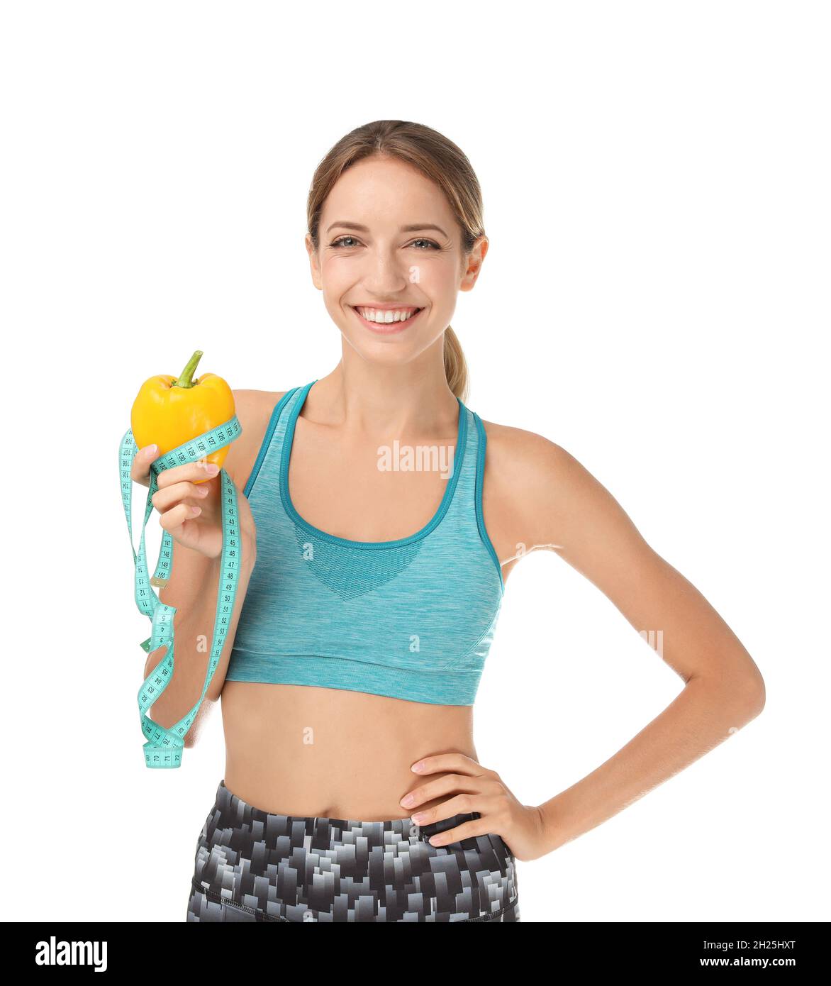 Happy slim woman with bell pepper and measuring tape on white ...