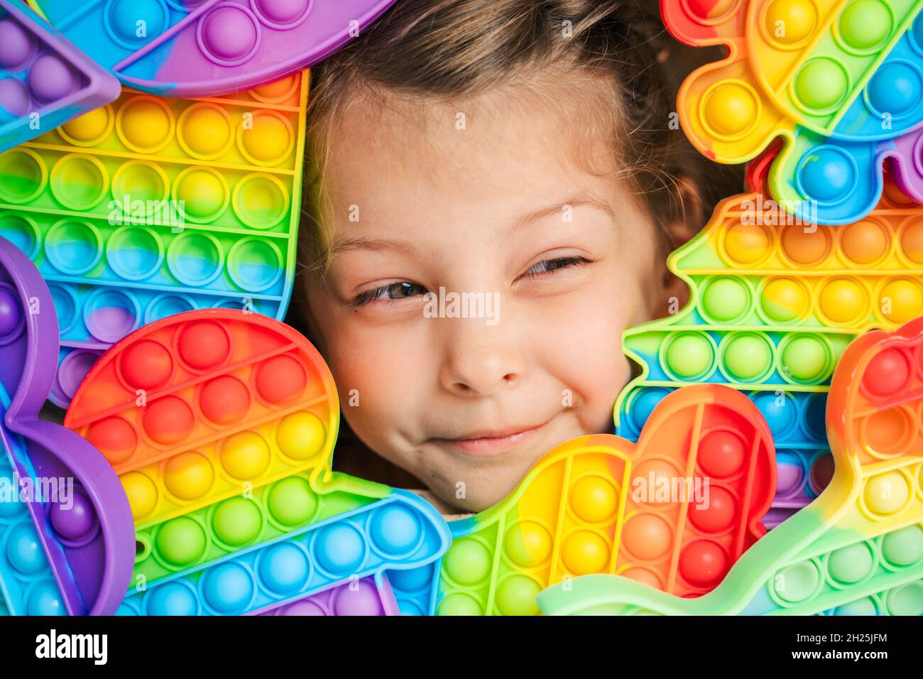 Little girl,kid,child head among many,lots of colorful pop it. Children ...