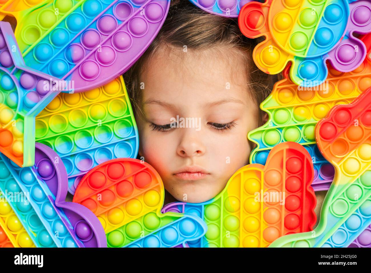 Little girl,kid,child head among many,lots of colorful pop it. Children ...