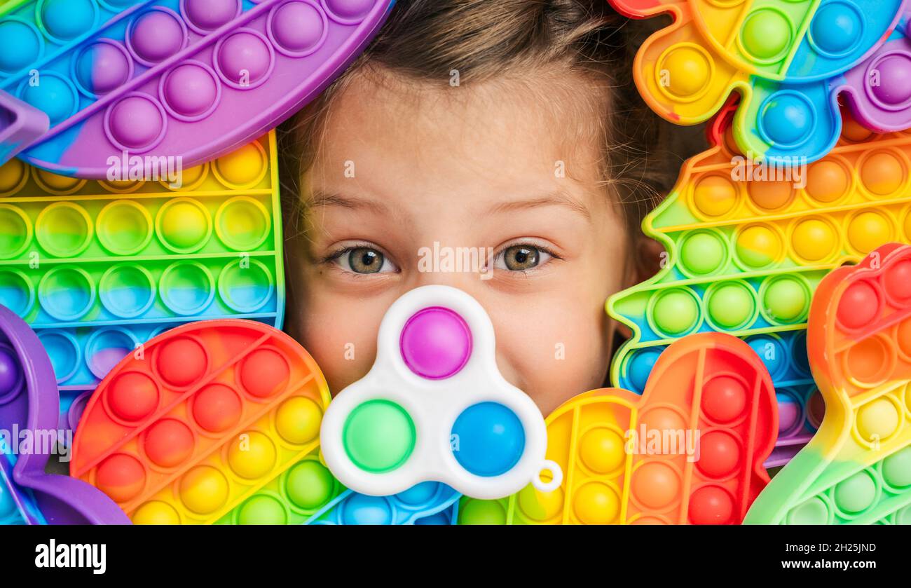 Little girl,kid,child head among many,lots of colorful pop it. Children ...