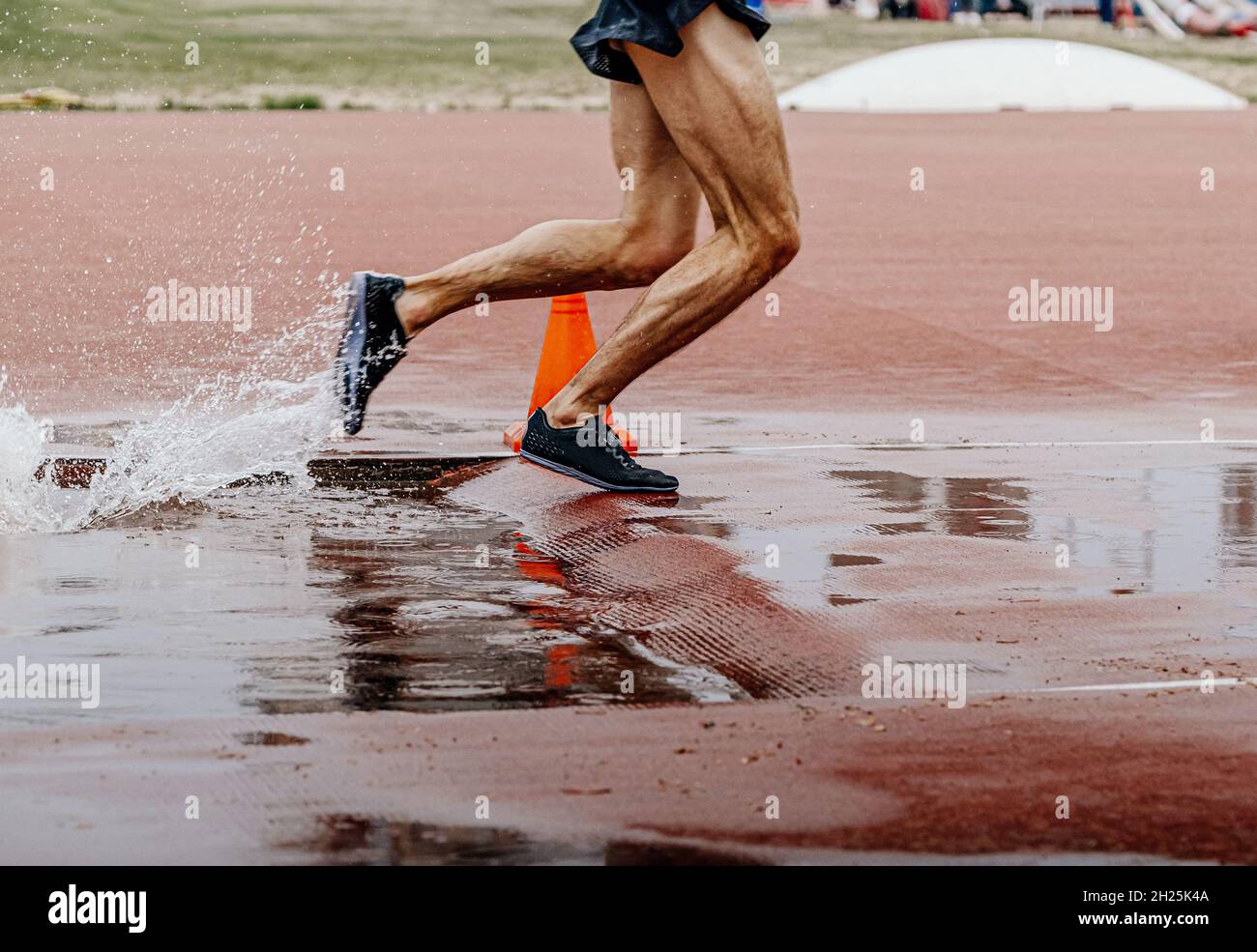 male runner athlete running steeplechase in athletics Stock Photo - Alamy