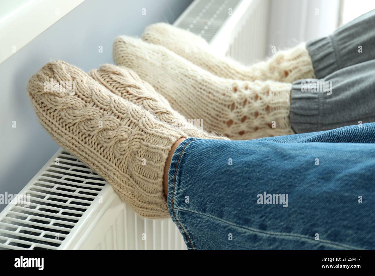Concept of heating season with legs in knitted boots on radiator Stock ...