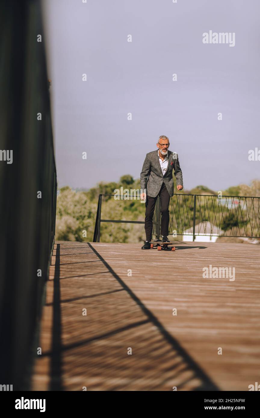 Concentrated bespectacled man getting ready for skateboarding Stock ...