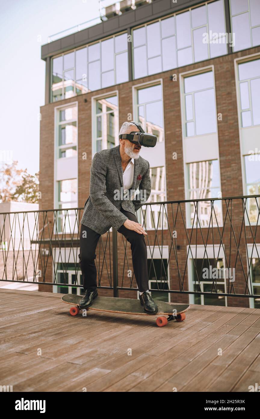 Skateboarding male gamer playing a 3D game outside Stock Photo - Alamy
