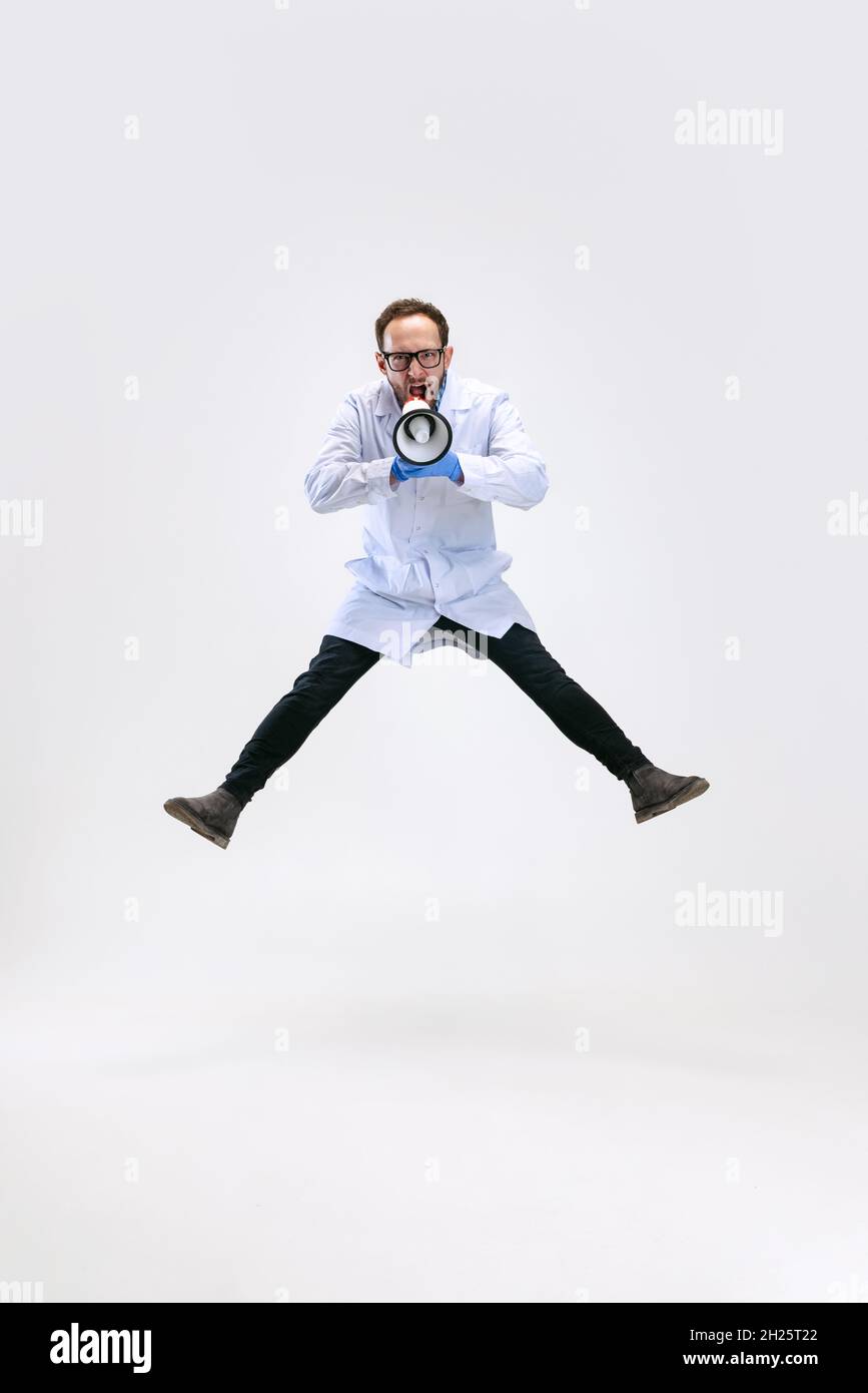 One excited man, chemist, doctor jumping and shouting at megaphone ...