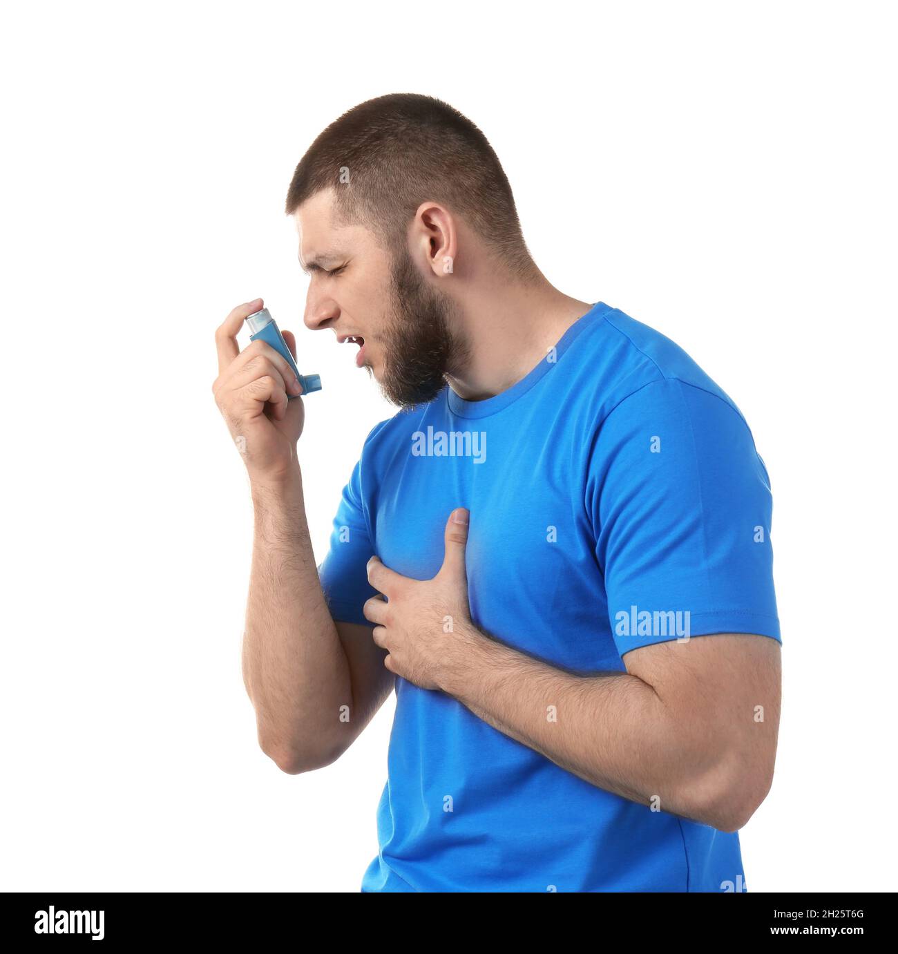 Young man using asthma inhaler on white background Stock Photo - Alamy