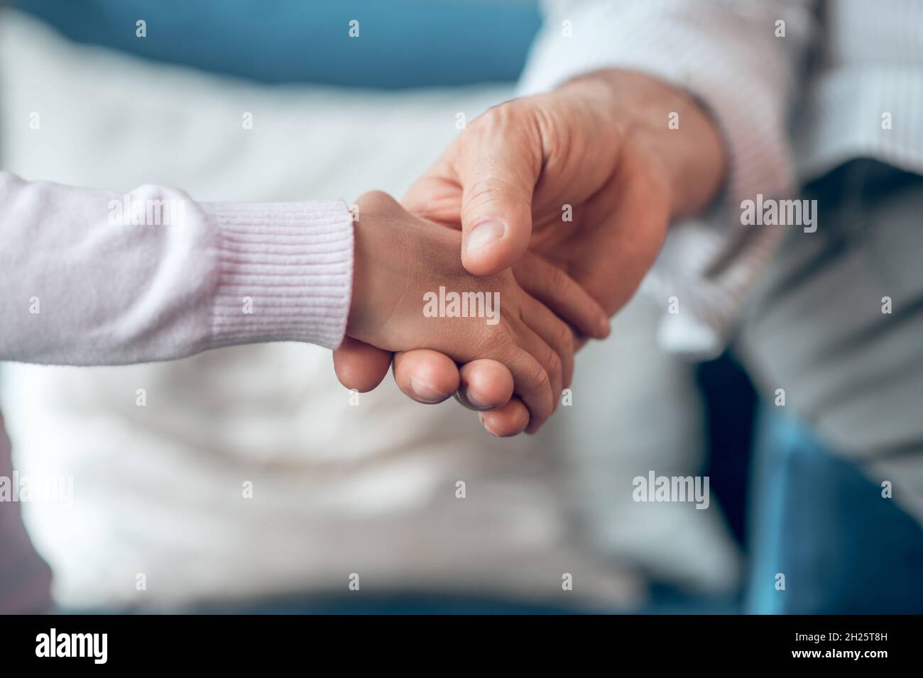 Close up picture of a mans hand holding kids hand Stock Photo - Alamy