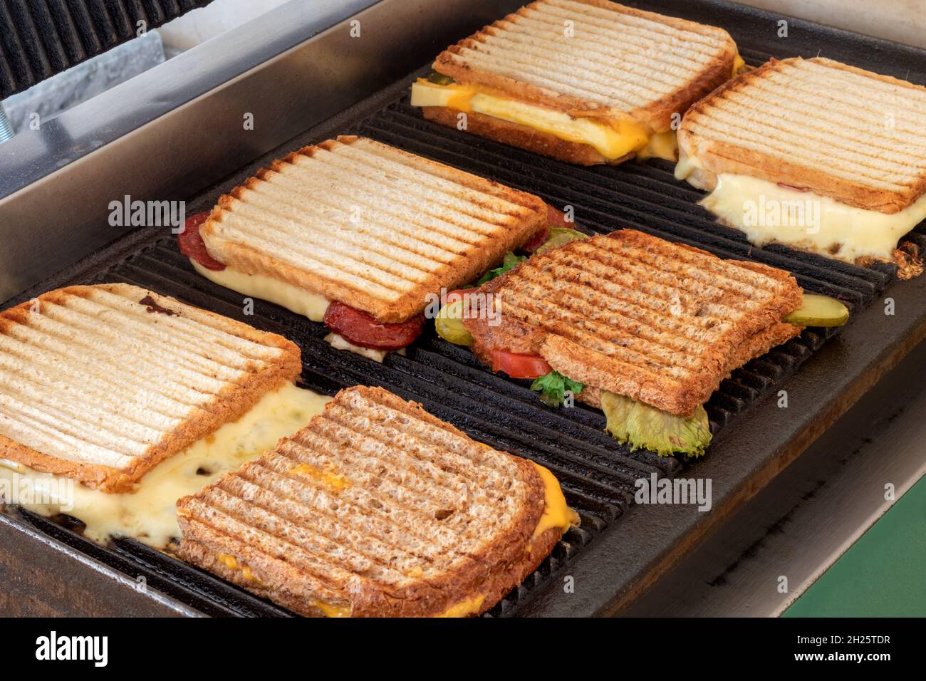 Toasted sandwiches with melting cheese on toaster or grill Stock Photo ...