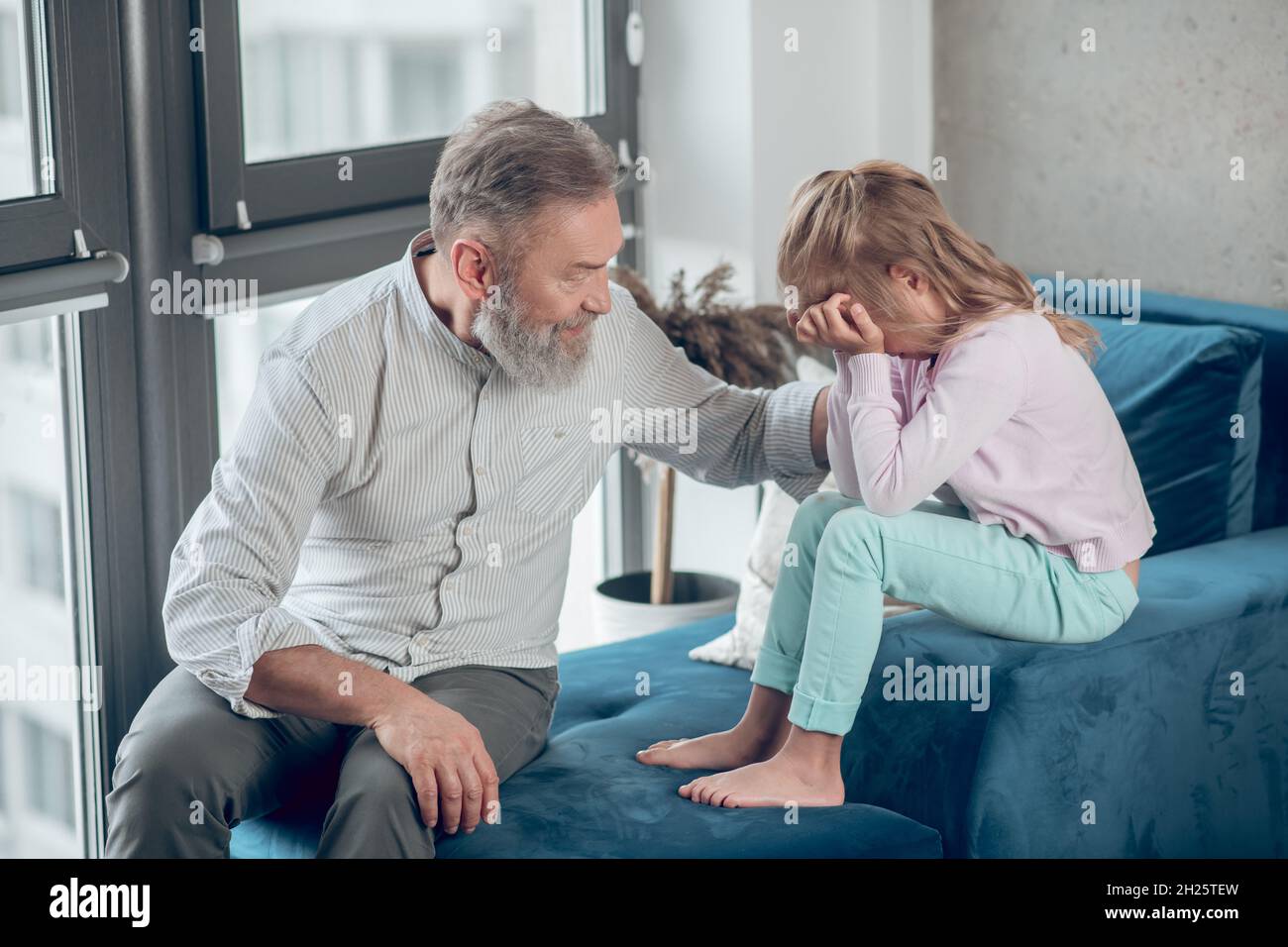 A man talking to his upset little daughter Stock Photo - Alamy