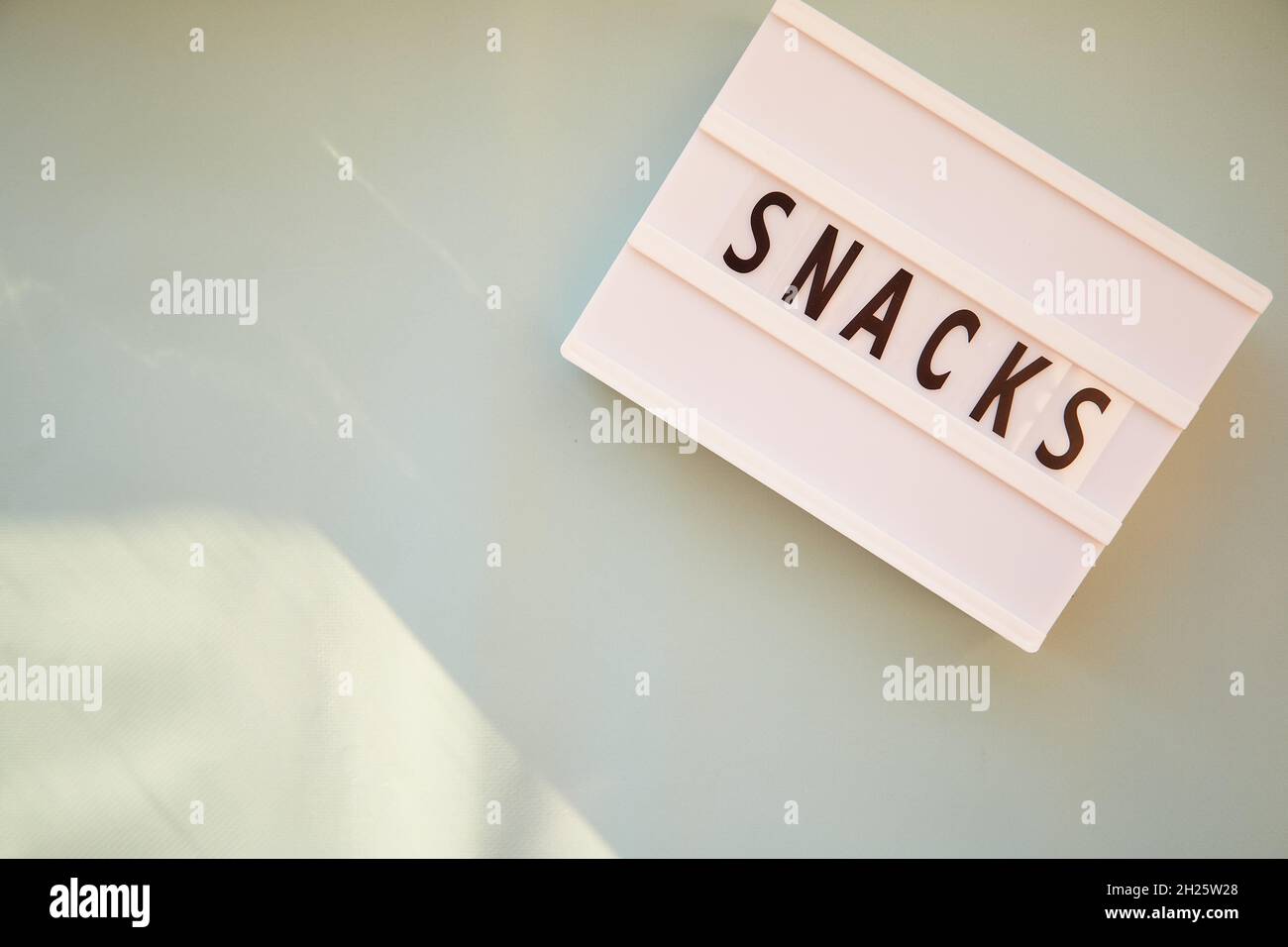 Text snacks with copy space and trendy shadows. Top view. Proper ...
