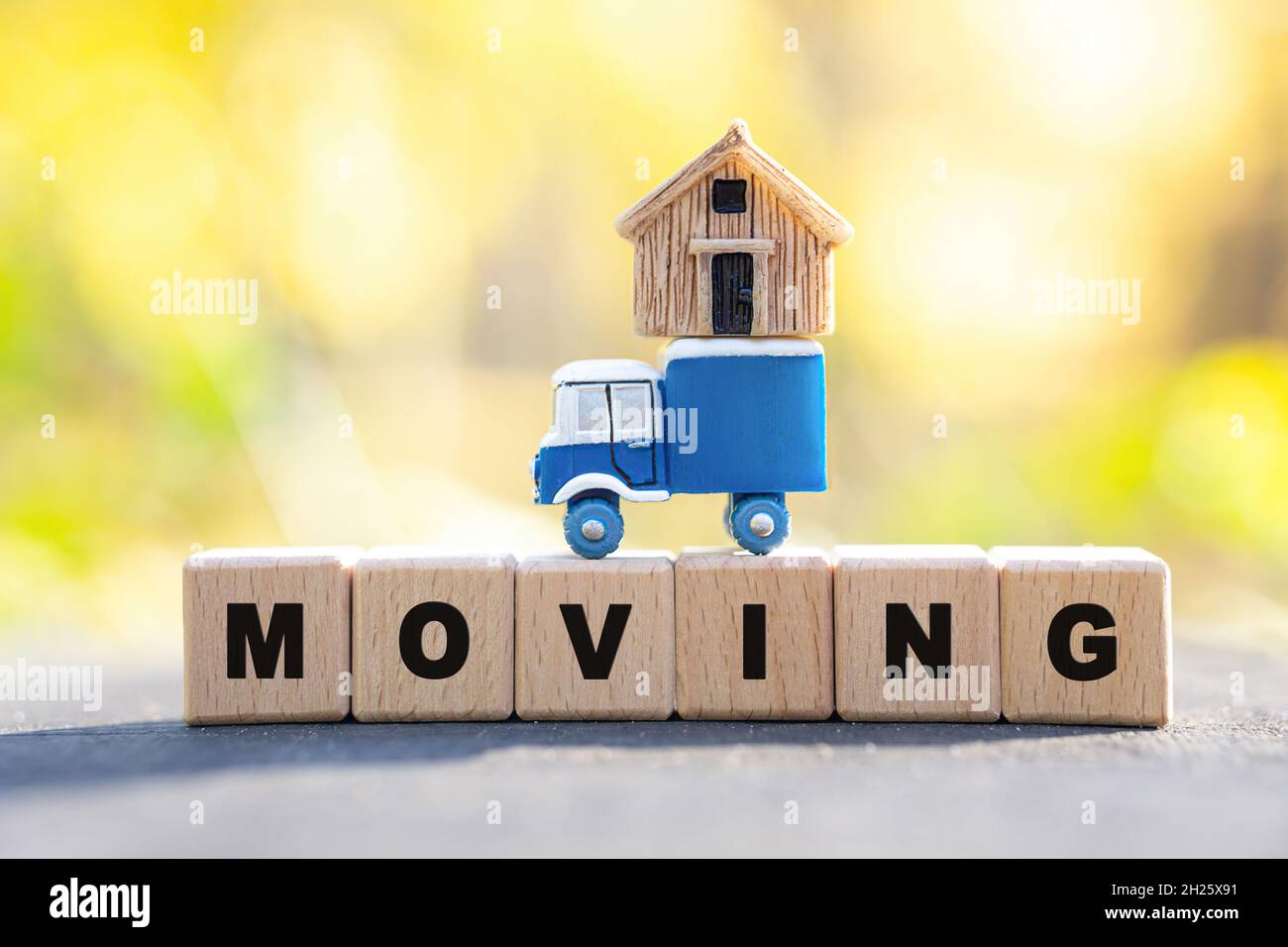 Word MOVING made of wooden letter blocks on a tree stump with a toy ...