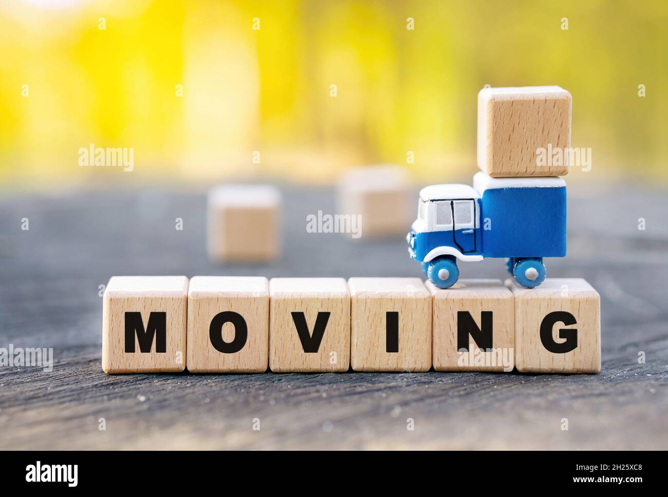 Word MOVING made of wooden letter blocks on a tree stump with a toy ...