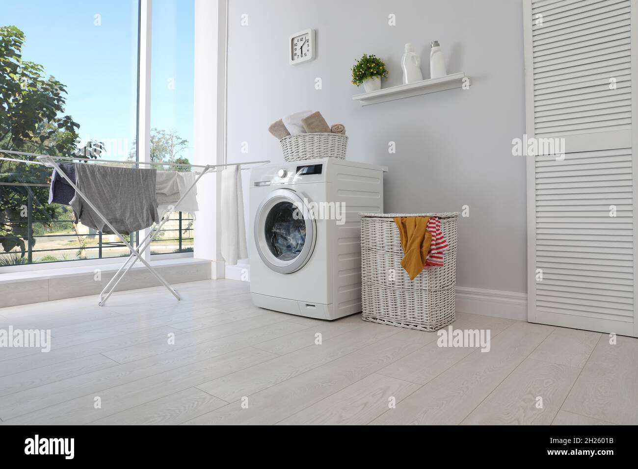 Laundry room interior with washing machine near wall Stock Photo - Alamy