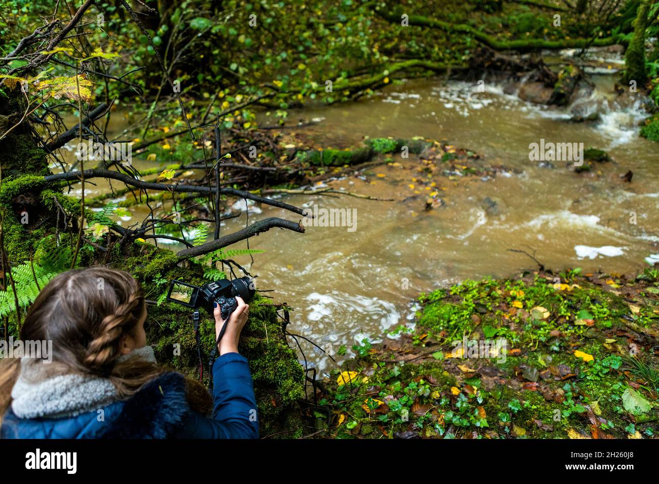 A young female photographer frames a slow shutter shot. Slade Brook ...