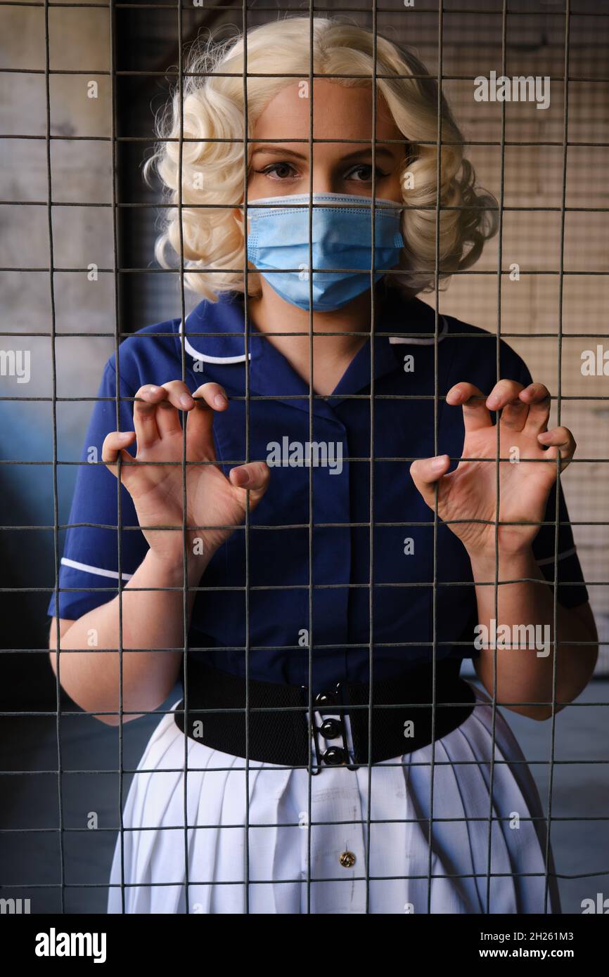 sad scared blond woman in mask behind bars close up portrait Stock ...
