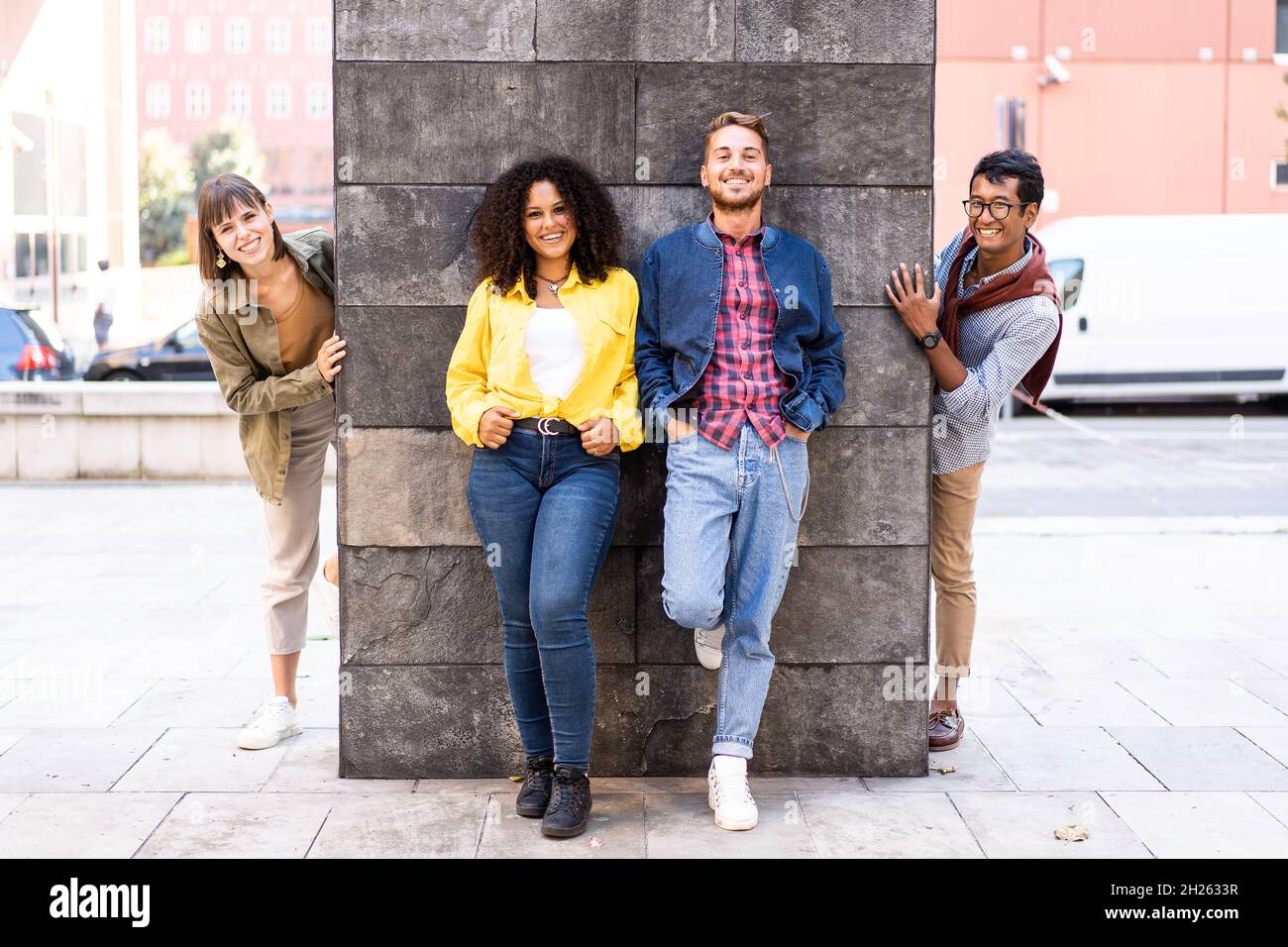 Multiracial friends group having fun at wall on university college ...