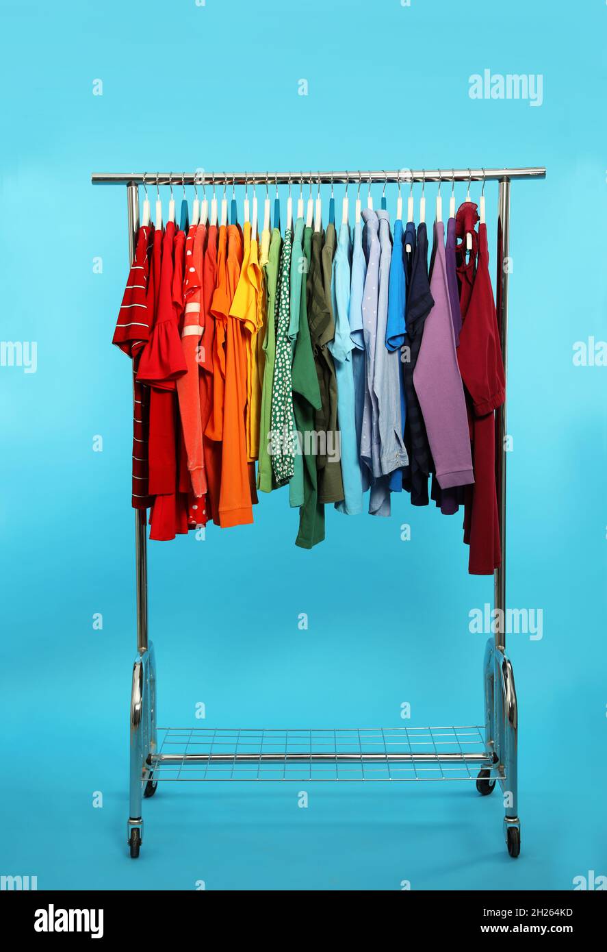 Wardrobe rack with different bright clothes on color background Stock ...