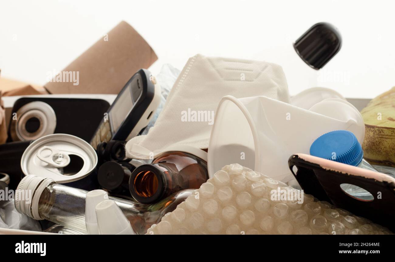 Stack of mixed waste materials laid on green isolated background. waste ...