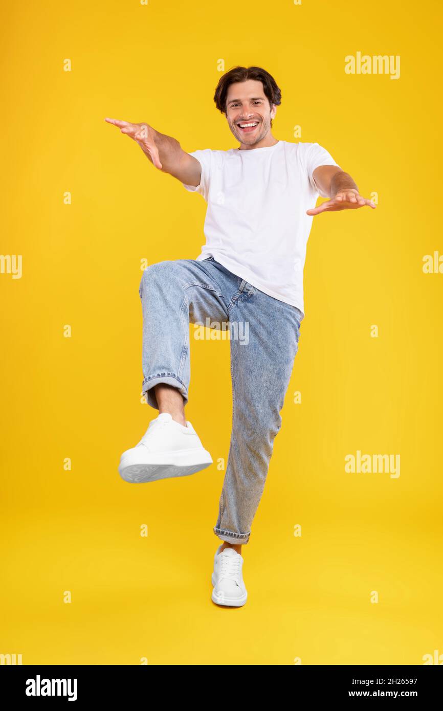Happy young man jumping and dancing at studio Stock Photo - Alamy