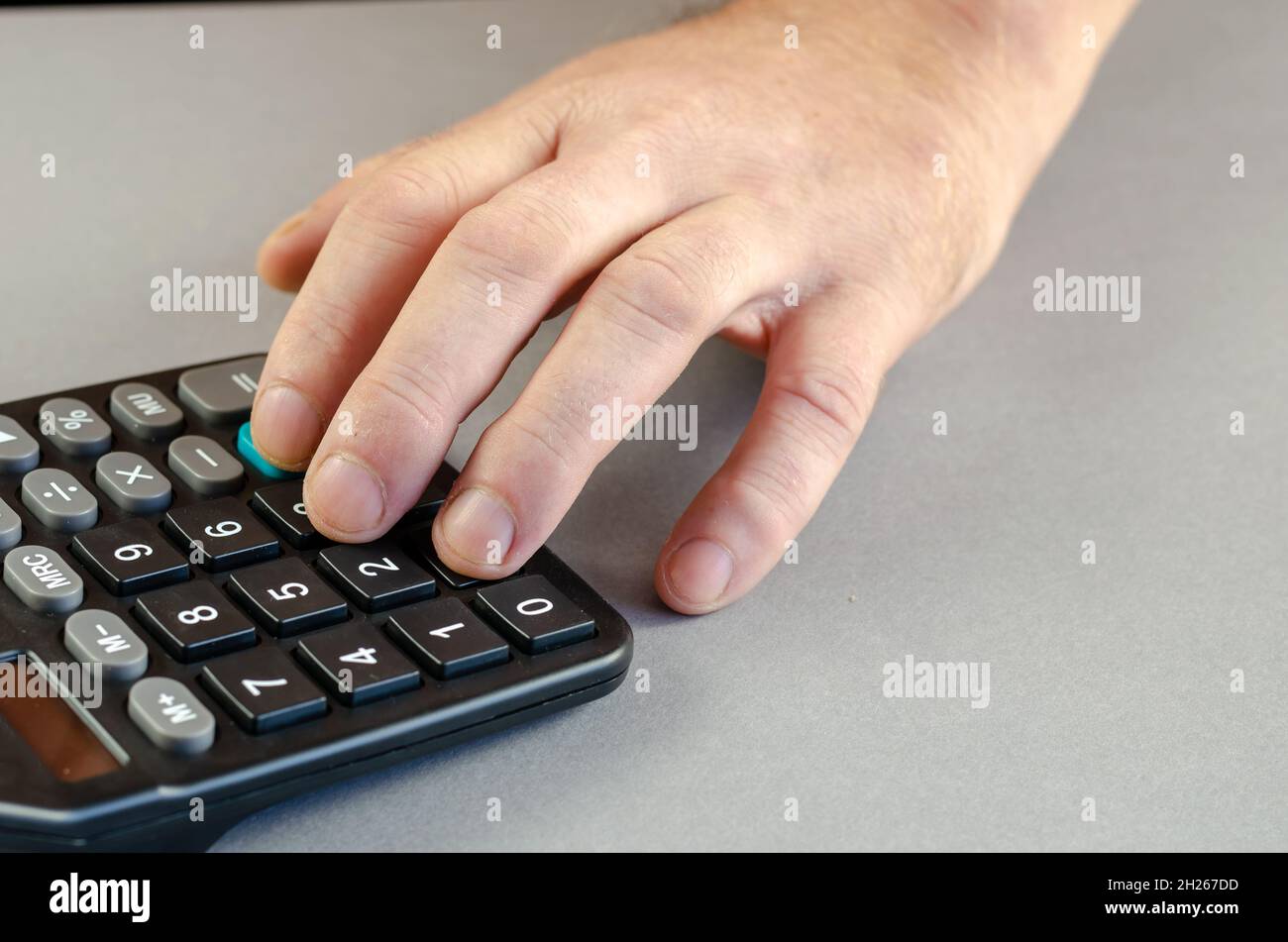 Man's fingers press the keys on black calculator. Financier performs ...