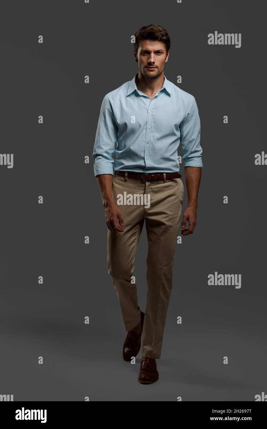 Young beautiful confident european businessman walking. Front view of ...