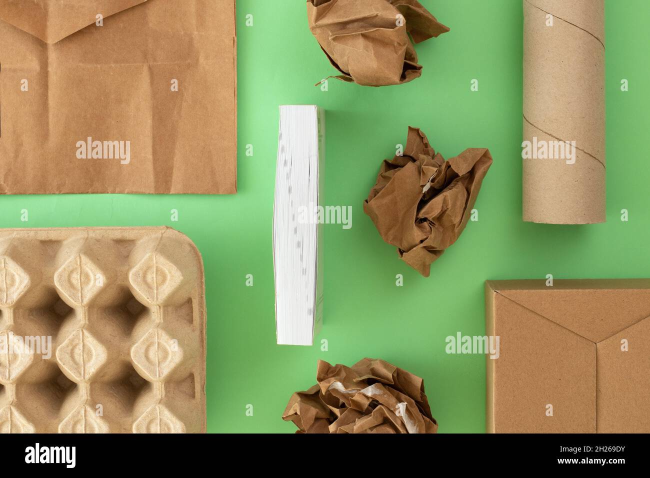 Paper waste materials laid on green isolated background. waste ...