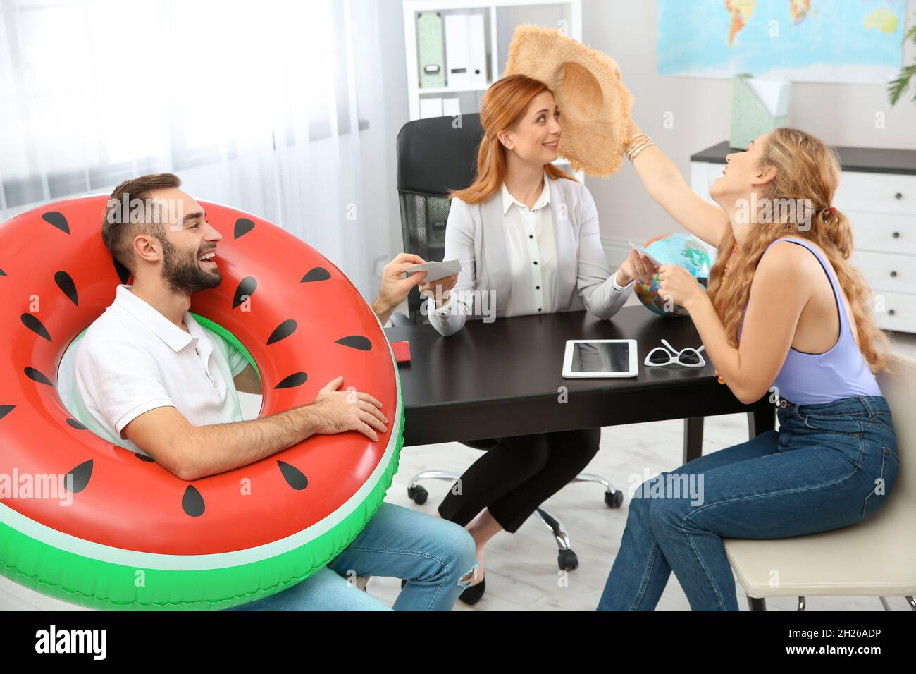 Beautiful young couple visiting travel agency office Stock Photo - Alamy