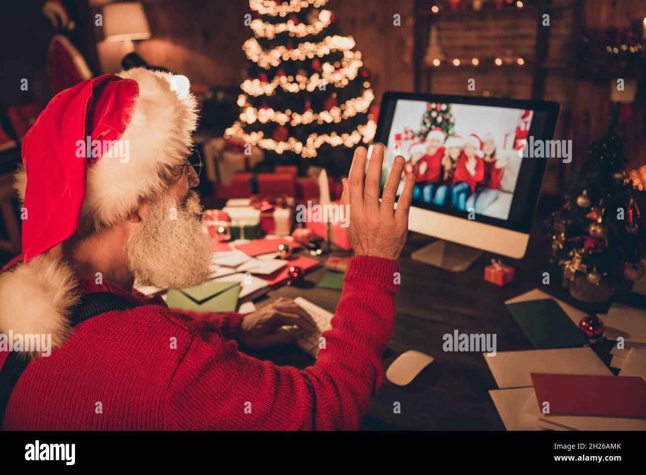 Back view photo portrait santa talking on video connection waving to ...