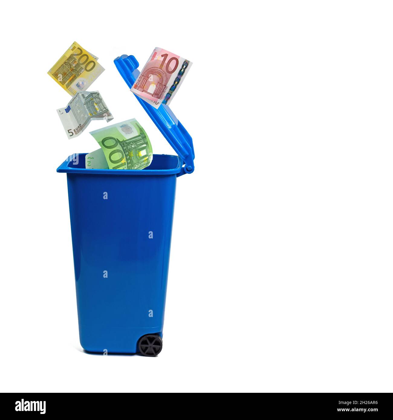 Dustbin and banknotes in front of a white background symbolic of waste ...