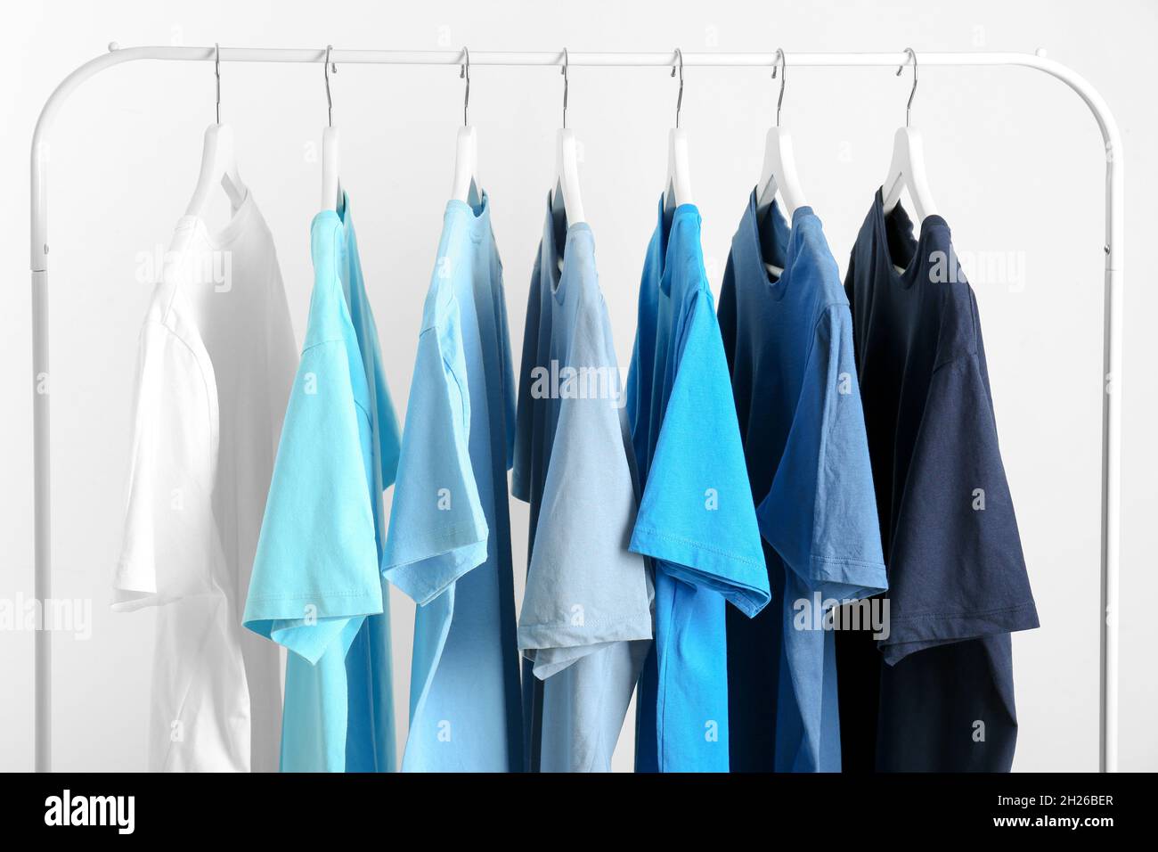 Men's clothes hanging on wardrobe rack against white background Stock ...