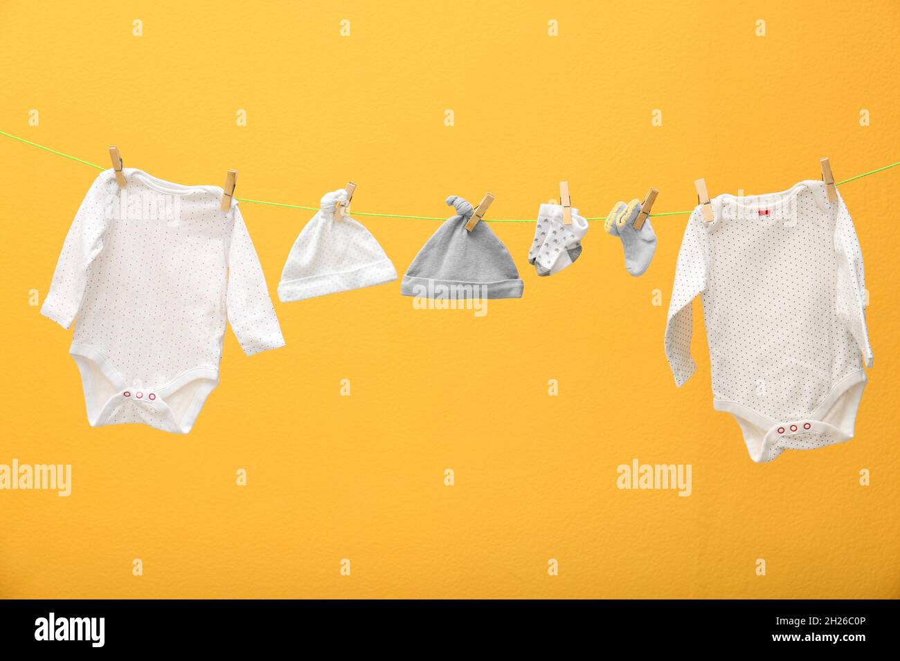 Children's clothes on laundry line against color background Stock Photo ...