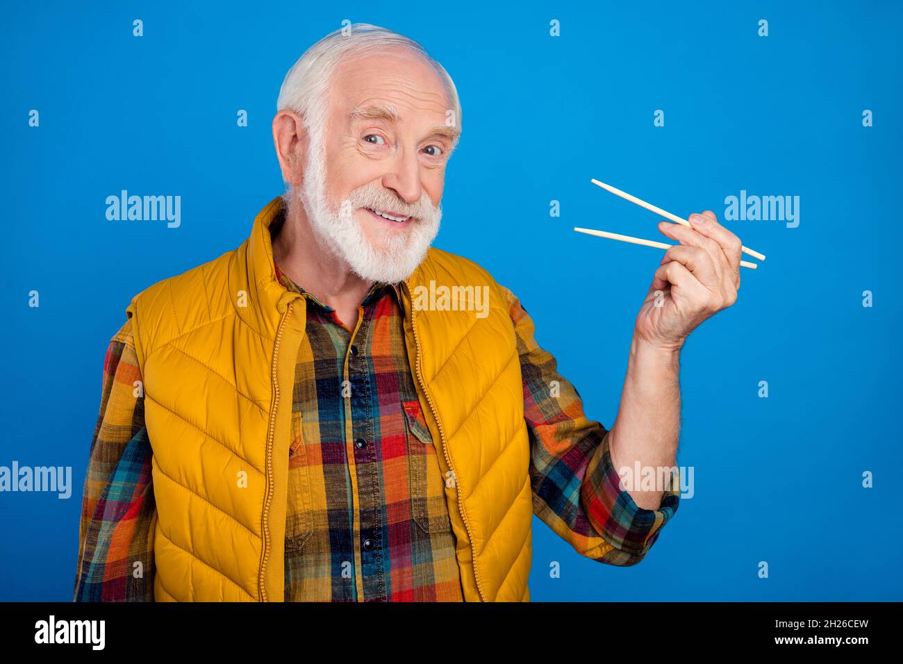 Portrait of attractive cheerful grey-haired man eating eastern food ...