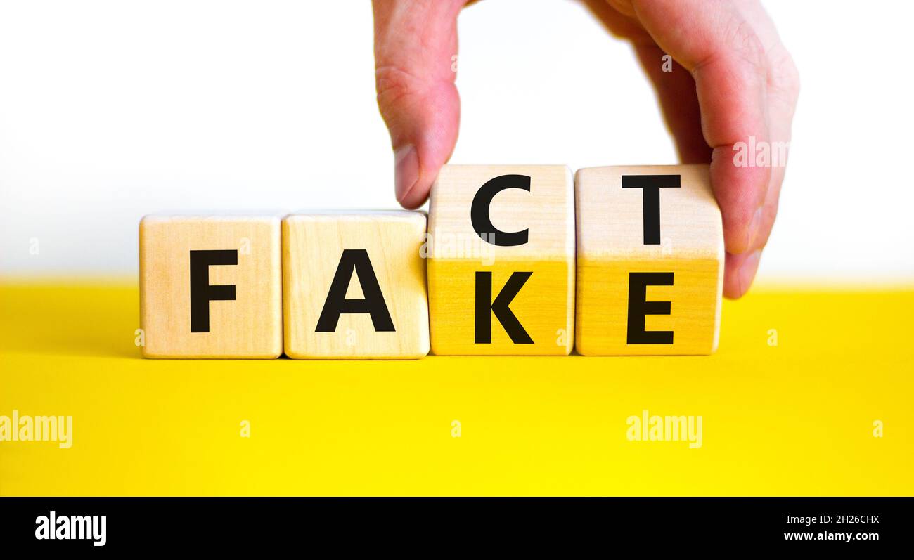 Fact or fake symbol. Businessman turn wooden cubes and changes the word ...
