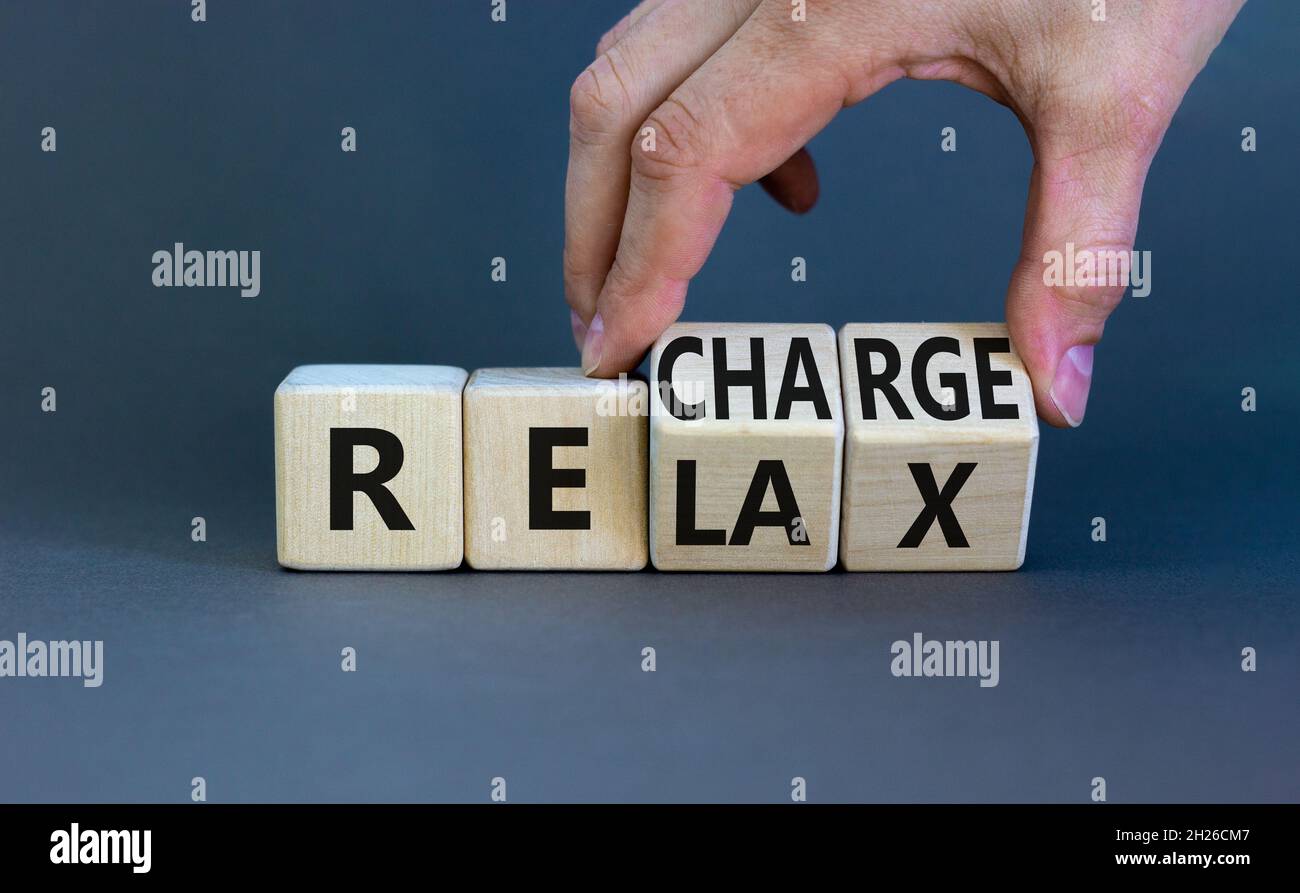 Relax and recharge symbol. Businessman turns cubes and changes the word ...