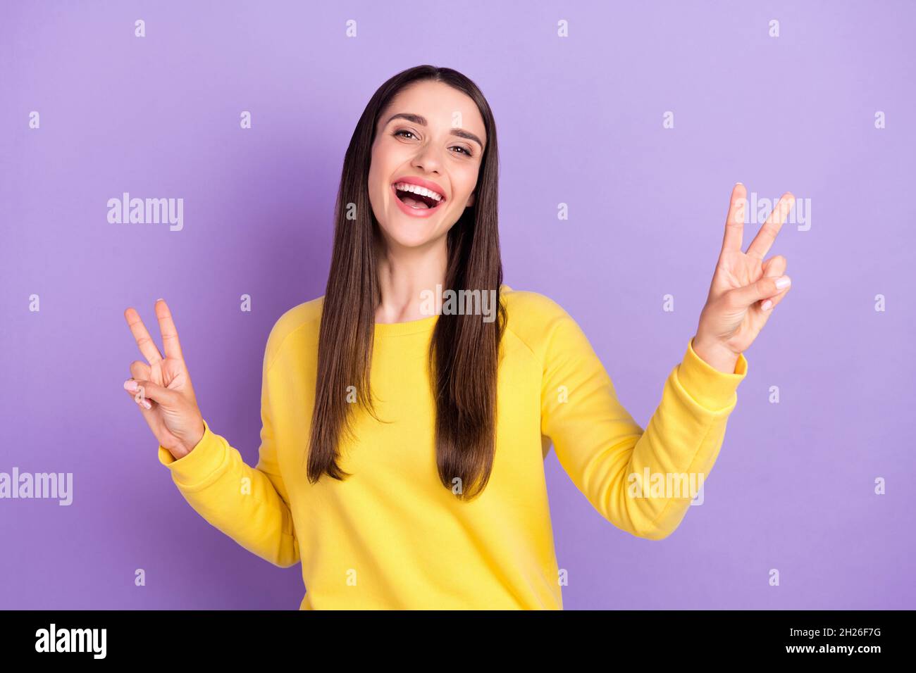 Portrait of attractive cheerful brown-haired girl showing double v-sign ...