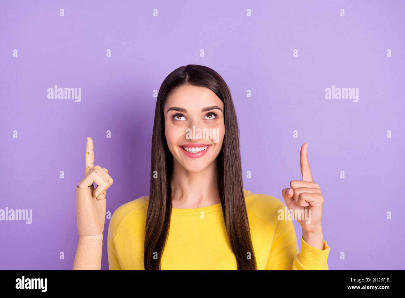 Portrait of attractive cheerful long-haired girl fake doll hand showing ...