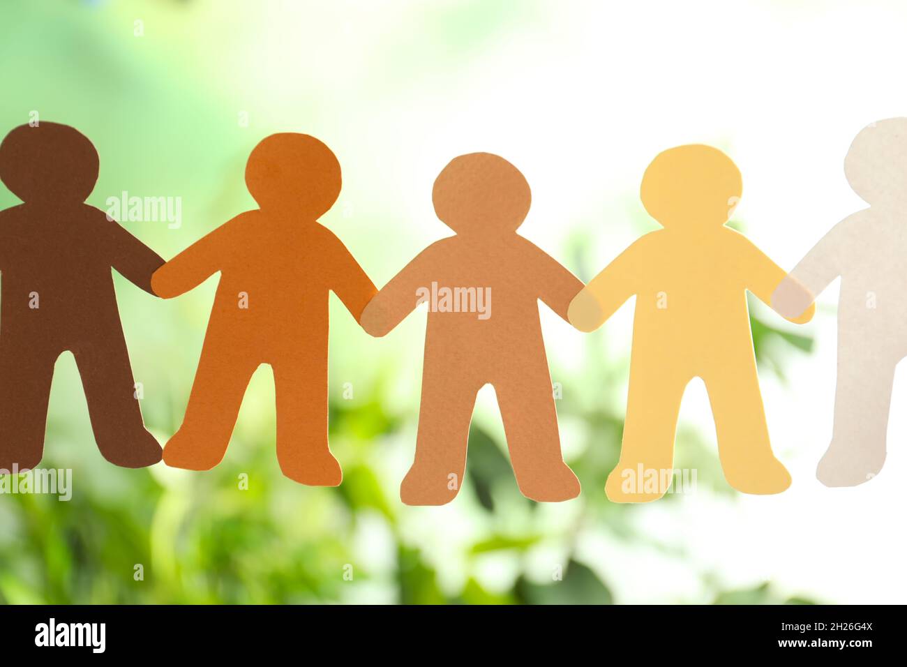 Paper people holding hands on blurred background. Unity concept Stock ...
