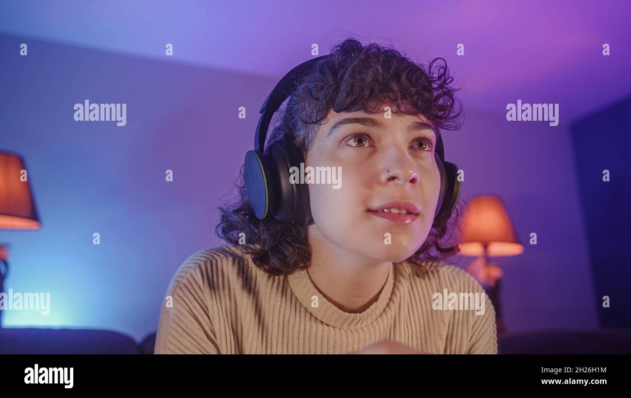 Portrait of beautiful gamer girl with curly-haired. Young girl sitting ...