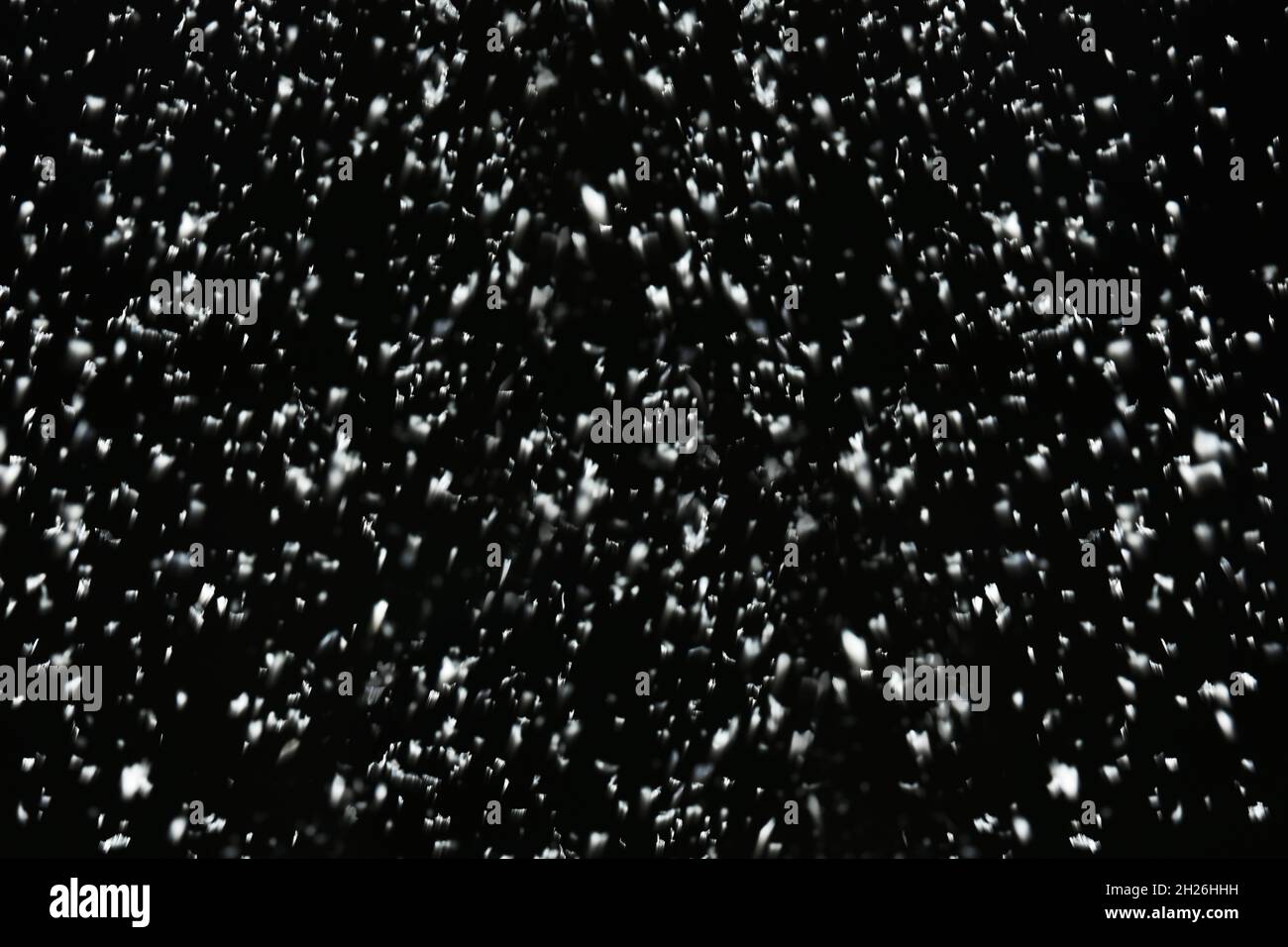 Snow flakes falling on black background. Winter weather Stock Photo - Alamy