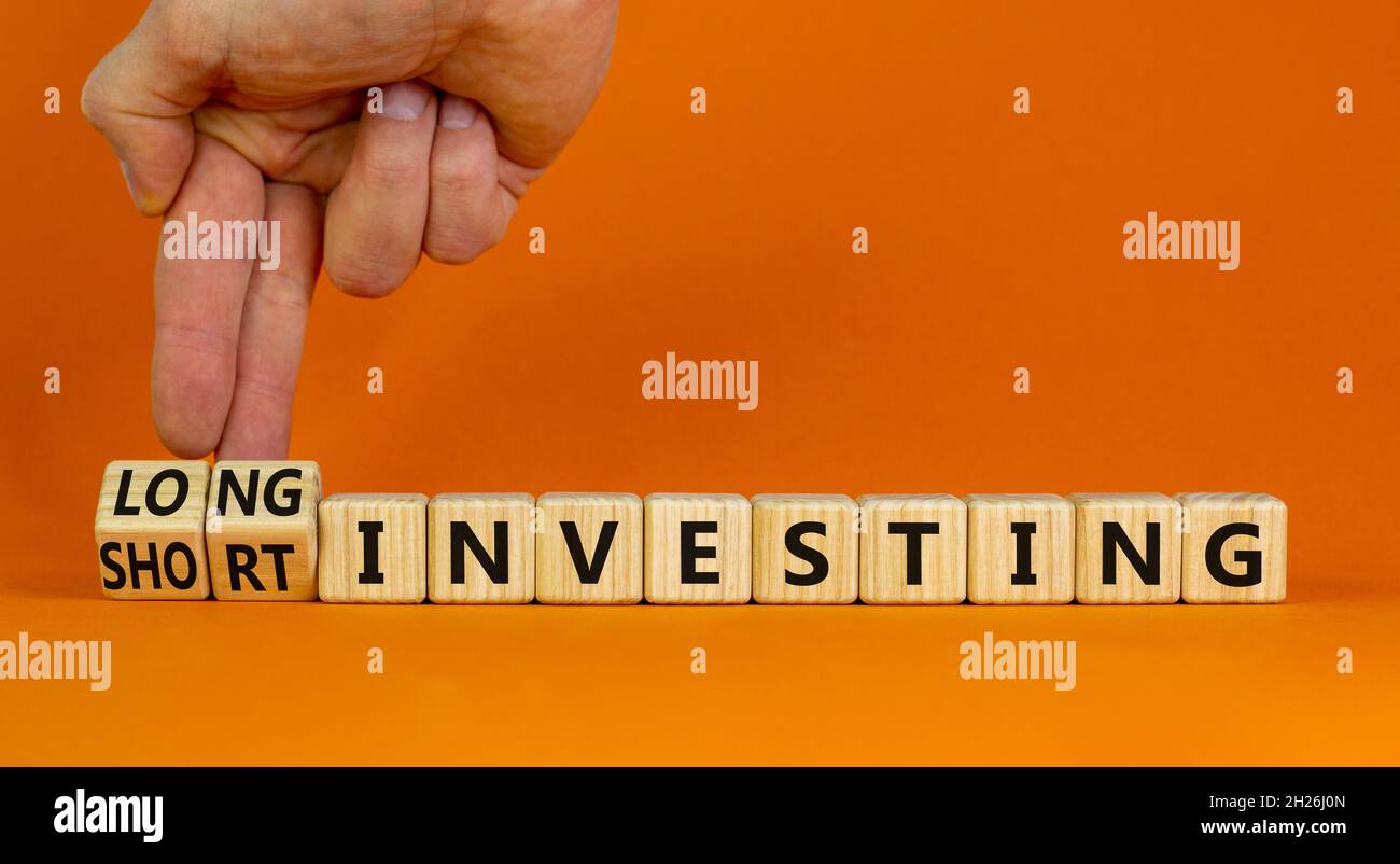 Short or long investing symbol. Businessman turns cubes and changes the ...